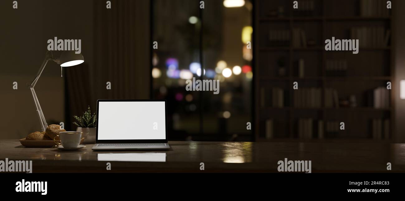 Close-up image of a dark workspace with white screen laptop computer ...
