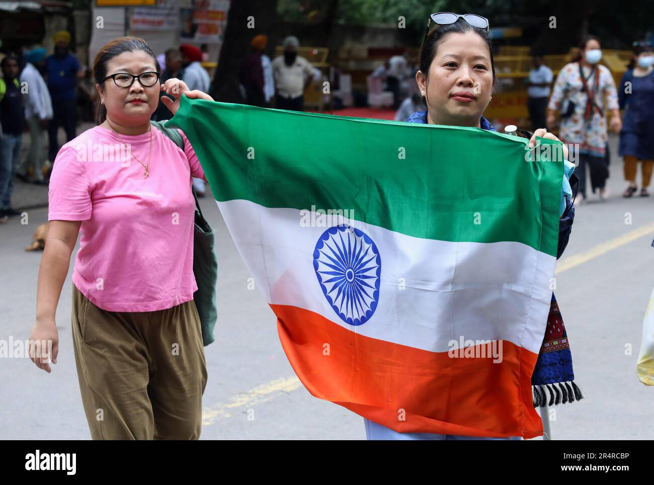 A woman belonging to Manipur 'Kuki tribe' holds an Indian flag during ...