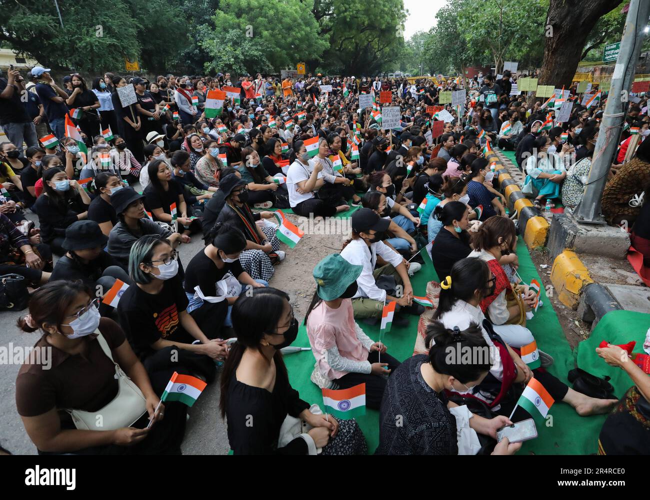 People belonging to Manipur 'Kuki tribe' sit in while holding Indian ...