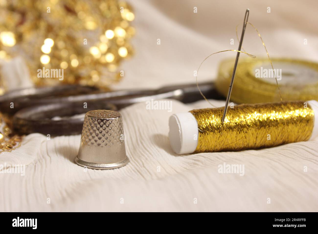 Spool of Gold Metallic Thread and Scissors With Thimble on Off White ...