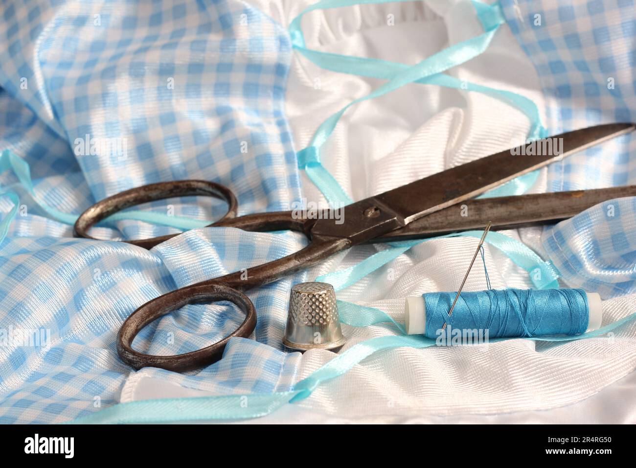 Spool of Blue Thread, Thimble and Needle on Vintage Blue and White ...