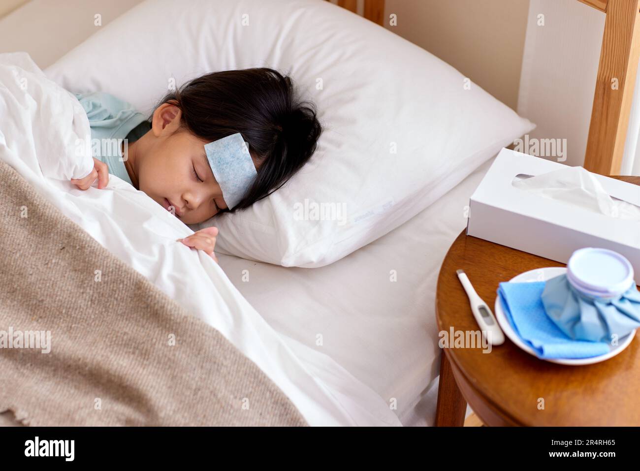 Japanese kid sick in bed Stock Photo - Alamy