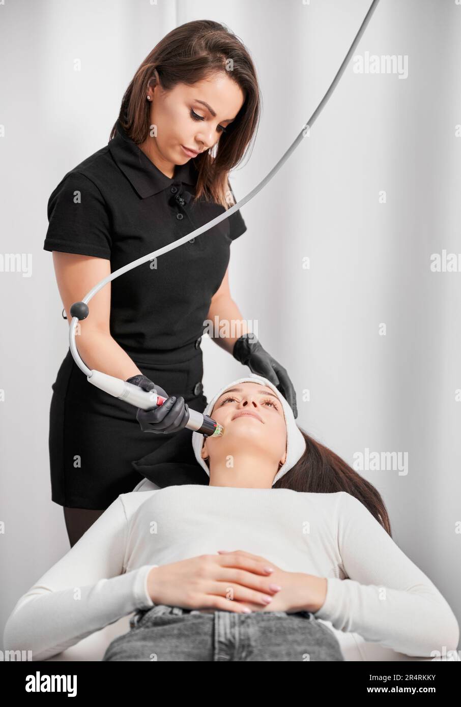 Medical esthetician cosmetologist using radiofrequency device while ...