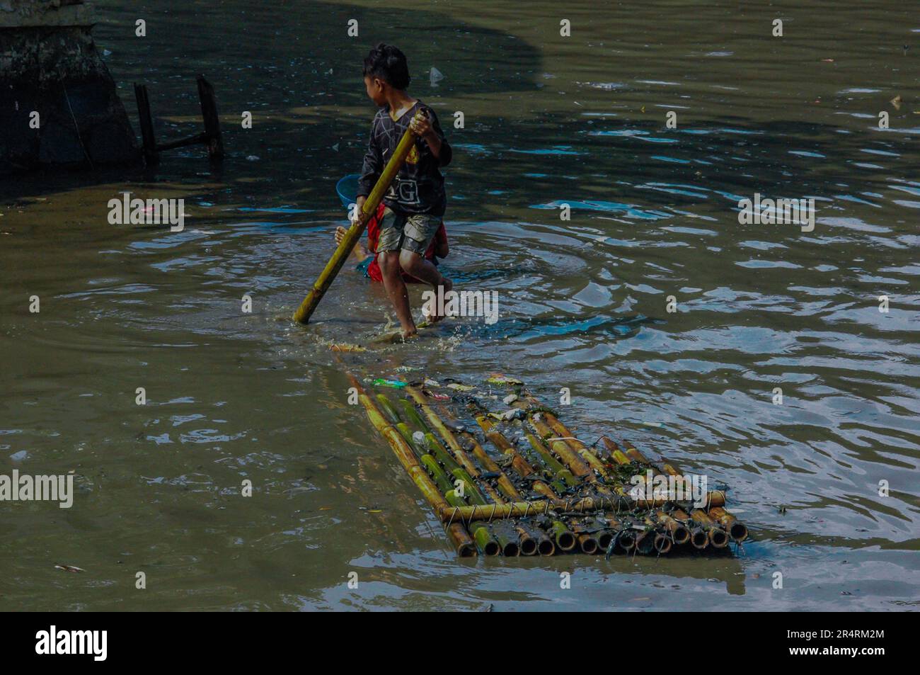 A kid crosses a river on a raft Stock Photo - Alamy