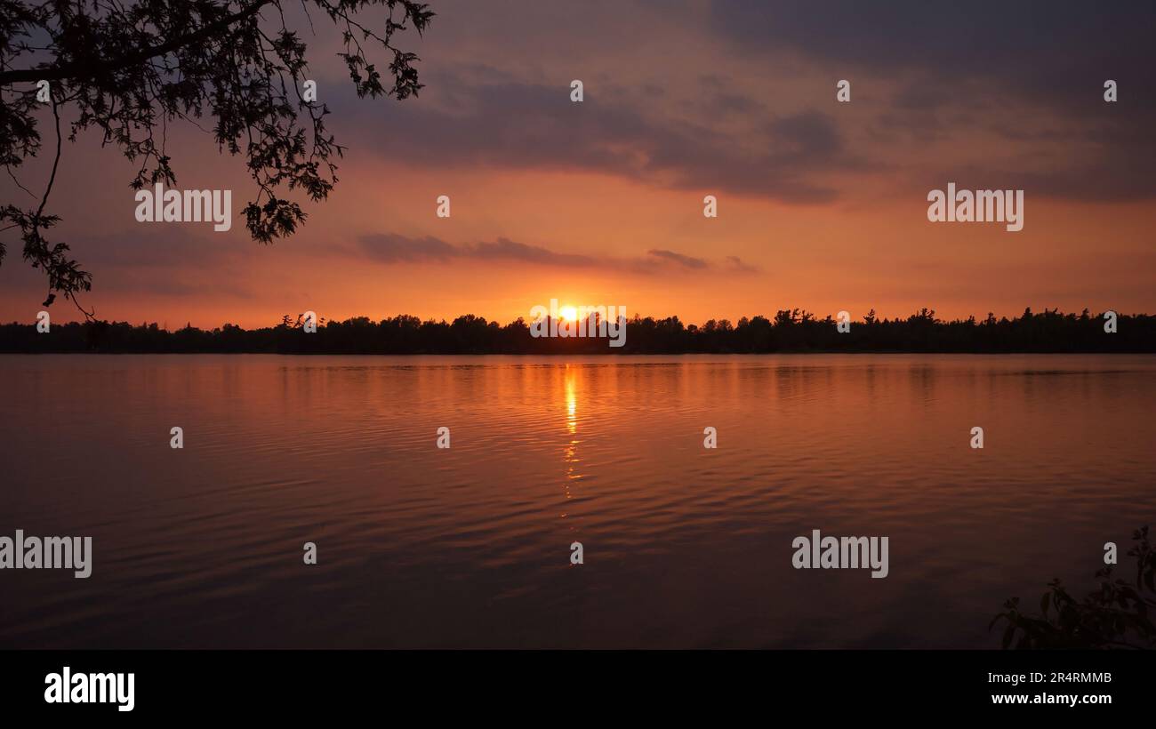 The end of a summer sunset, as the sun sinks behind the horizon line ...