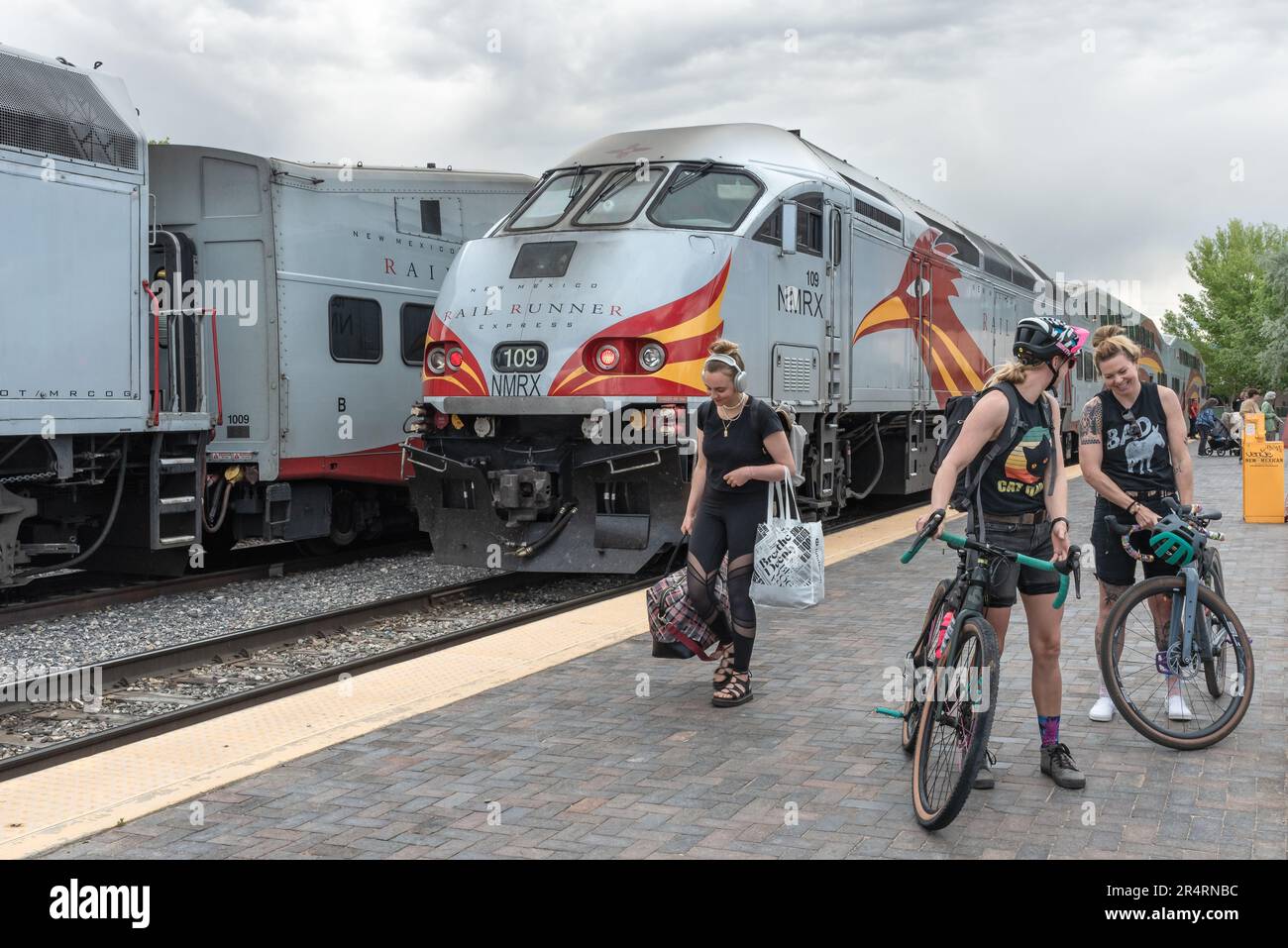On the sidewalk in the Rail Yard two young women stand with their ...