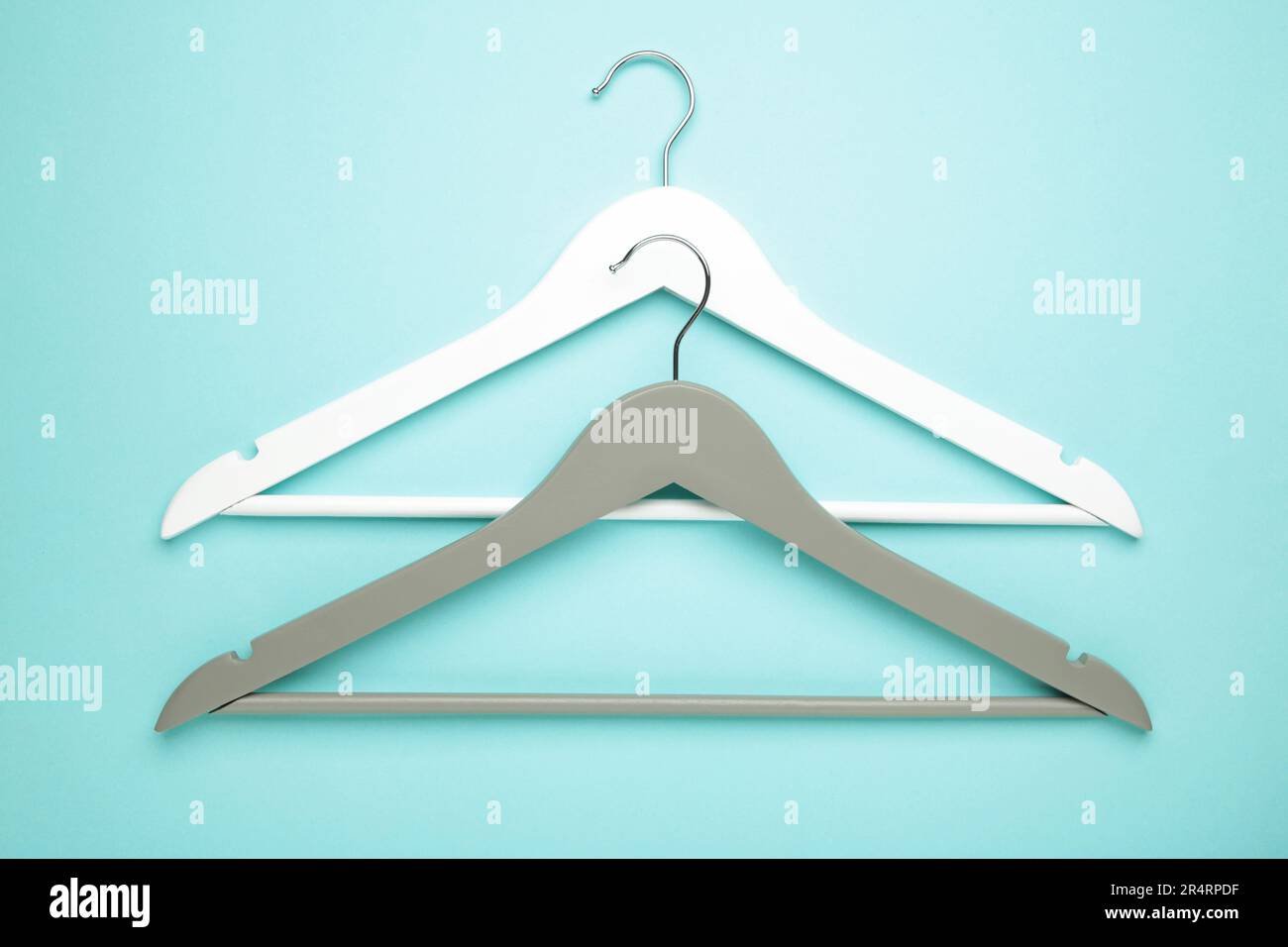 White and grey wooden hangers on blue background. Store concept, empty ...