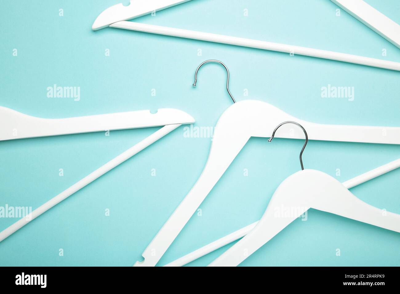 Many wooden white hangers on blue background. Store concept, empty ...