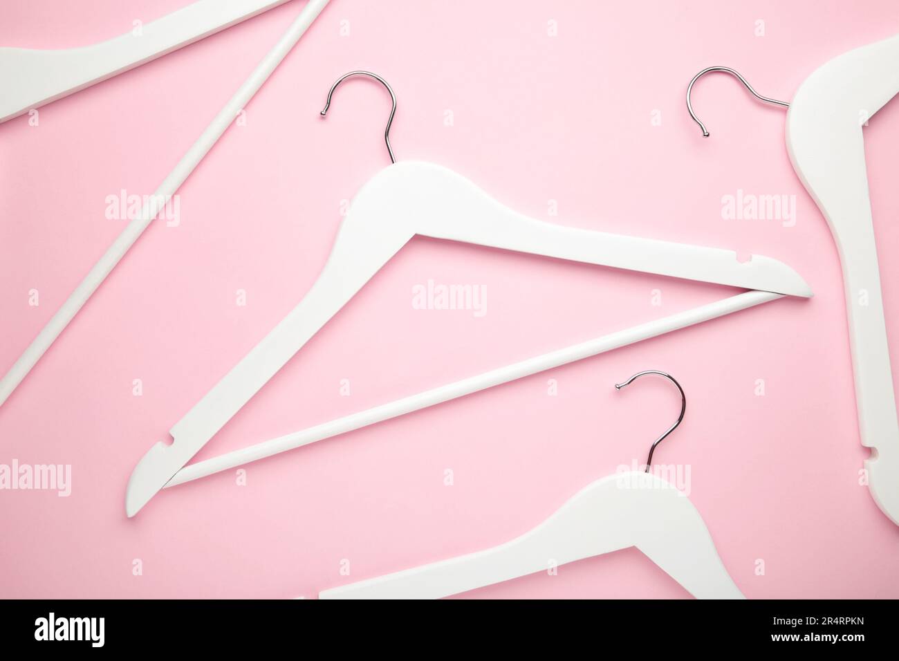 Many wooden white hangers on pink background. Store concept, empty ...