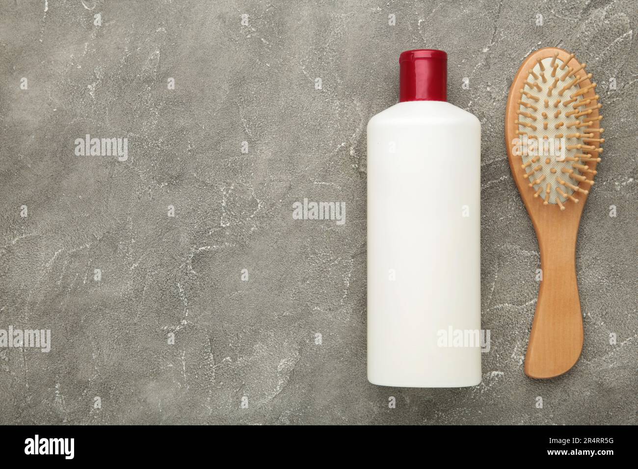 Hair styling concept with shampoo and combs on grey background. Flat ...