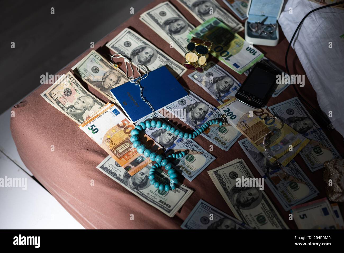 Crime scene, physical evidence. Gun handcuffs, money, dollar on a dark ...