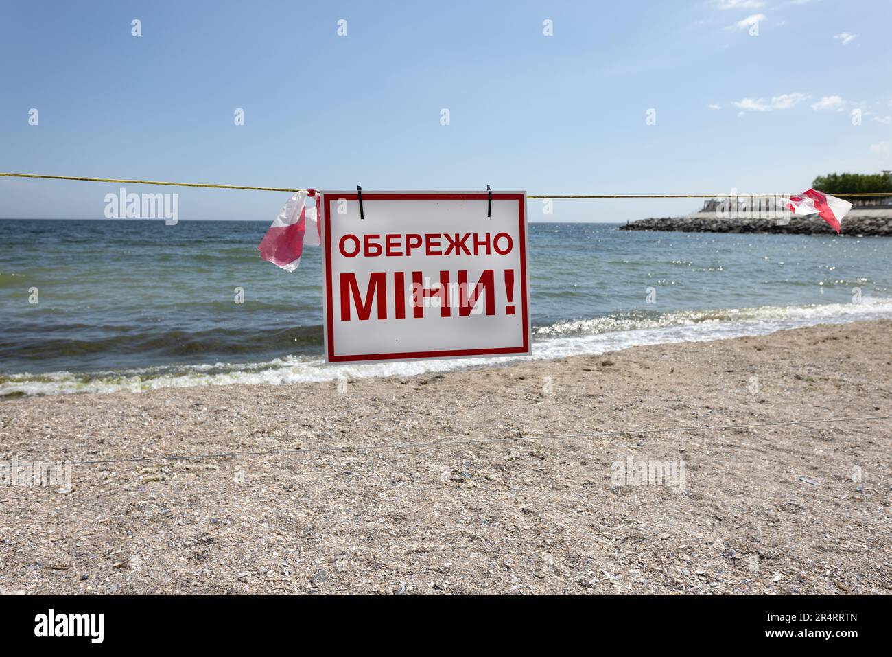 A bright red "Danger-mines" sign in Ukrainian is placed on the city's ...