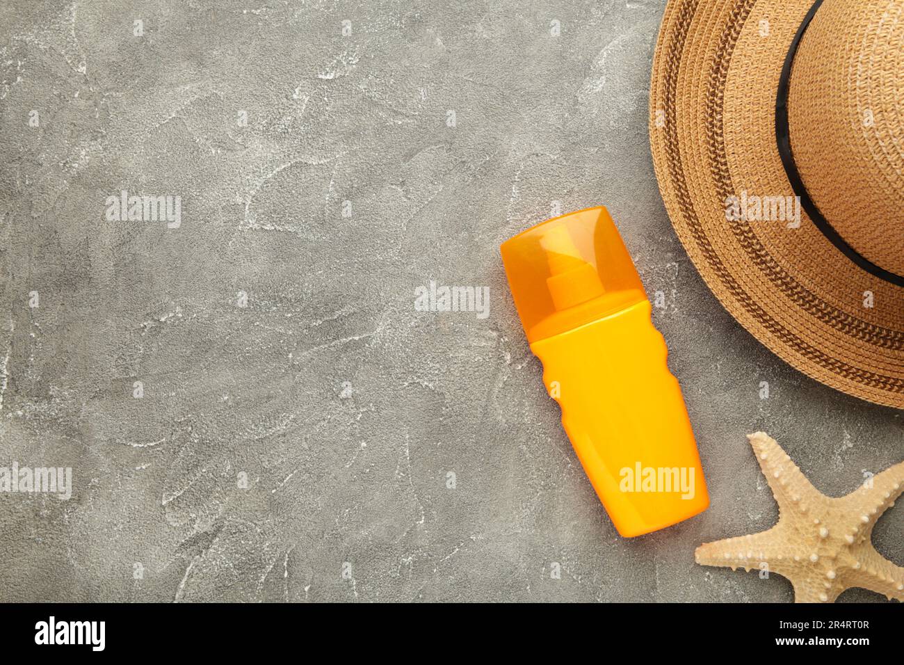 Sunscreen bottle with hat and shells on grey background. Cosmetics for ...