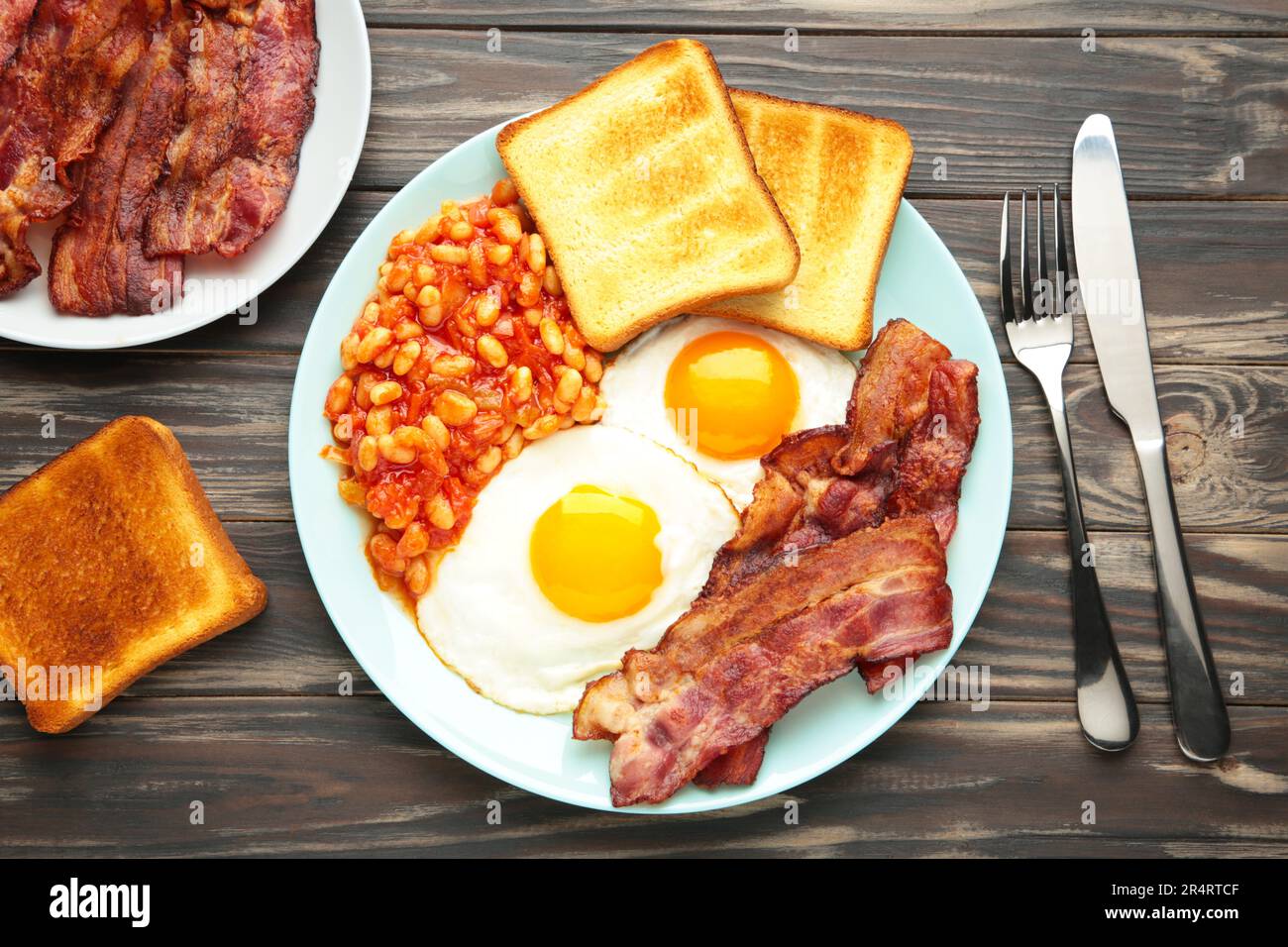 Traditional full English breakfast - fried eggs, beans, bacon and toast ...