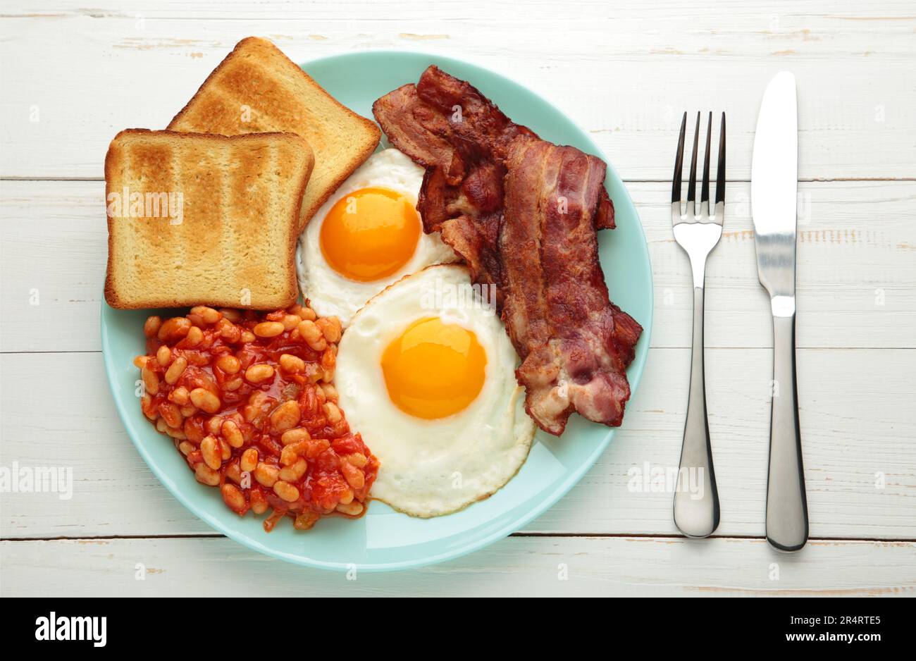Traditional full English breakfast - fried eggs, beans, bacon and toast ...