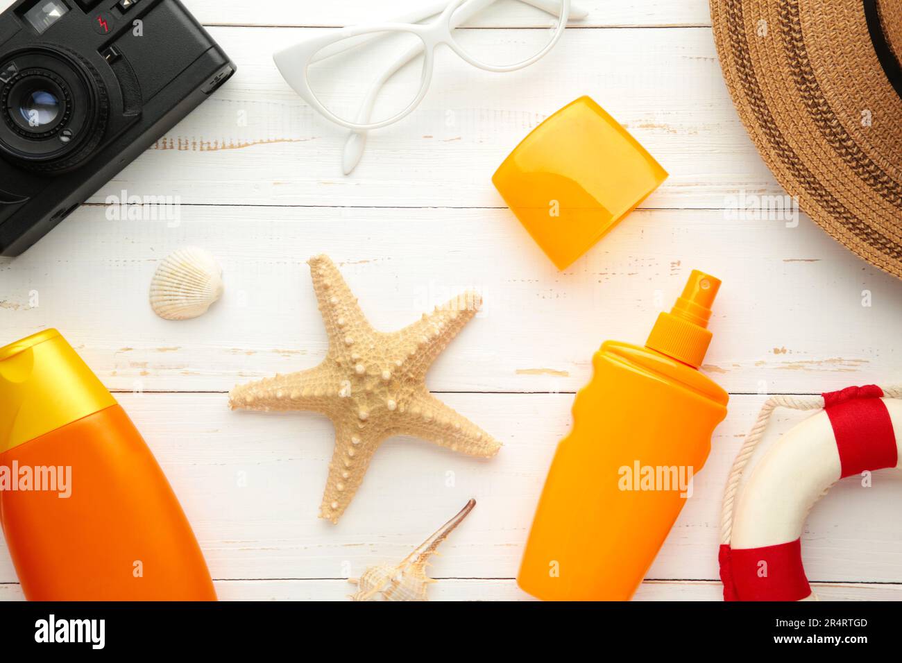 Sunscreen bottle with hat, glasses and other accessories on white ...