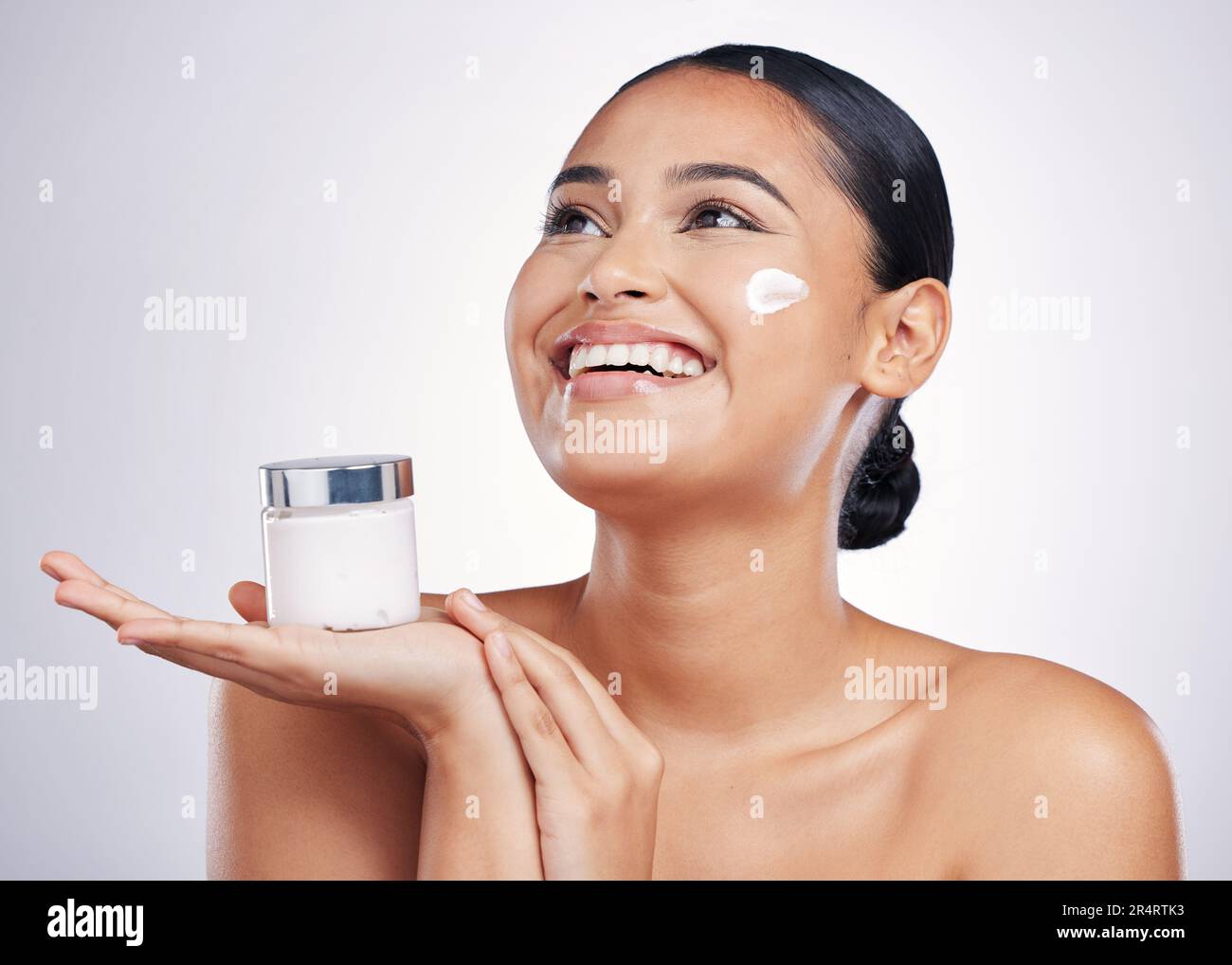 Happy woman, face and thinking with cream in skincare, moisturizer or ...