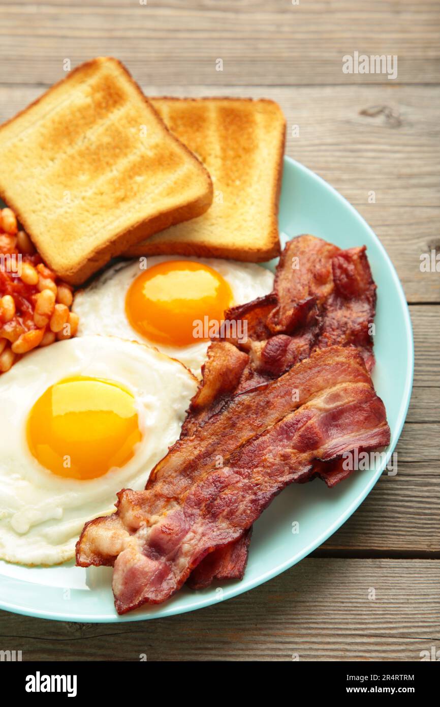 Traditional full English breakfast - fried eggs, beans, bacon and toast ...