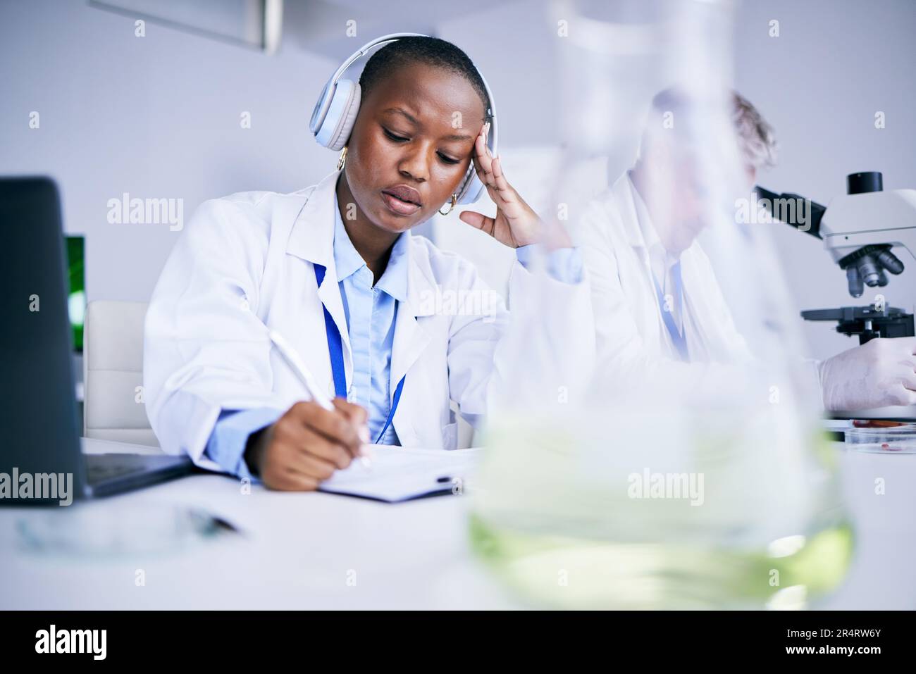 Science, tired and black woman with a headache, writing or burnout with ...