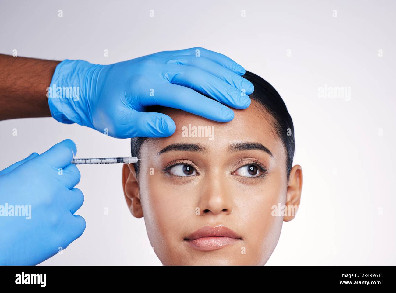 Woman, studio and injection with hands, surgery or worry with thinking ...