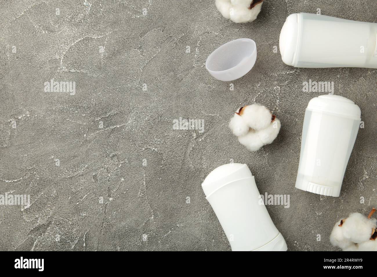 Different deodorants with cotton on grey background with copy space ...