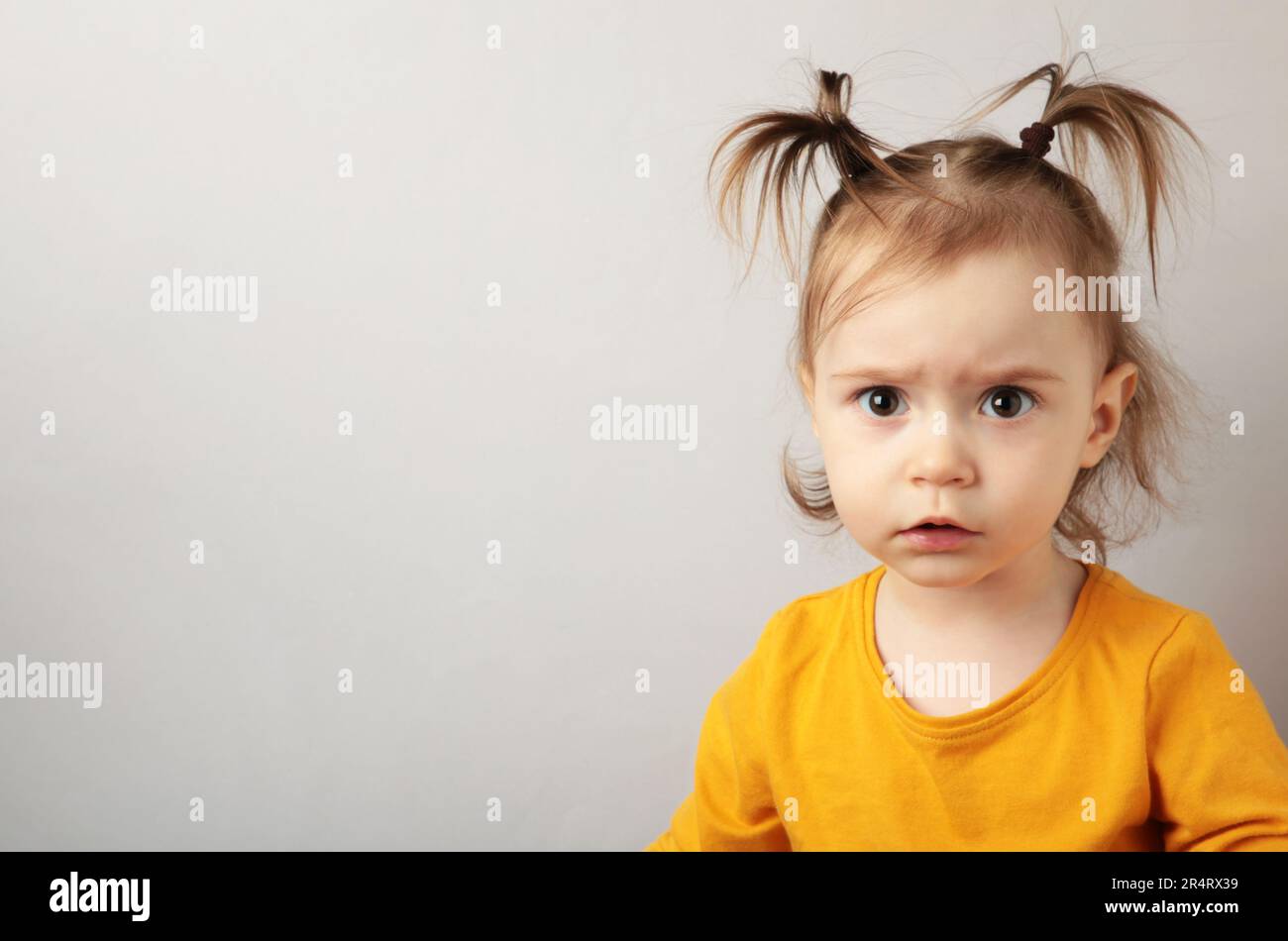 Portrait of angry little girl on blue background with copy space. Top ...