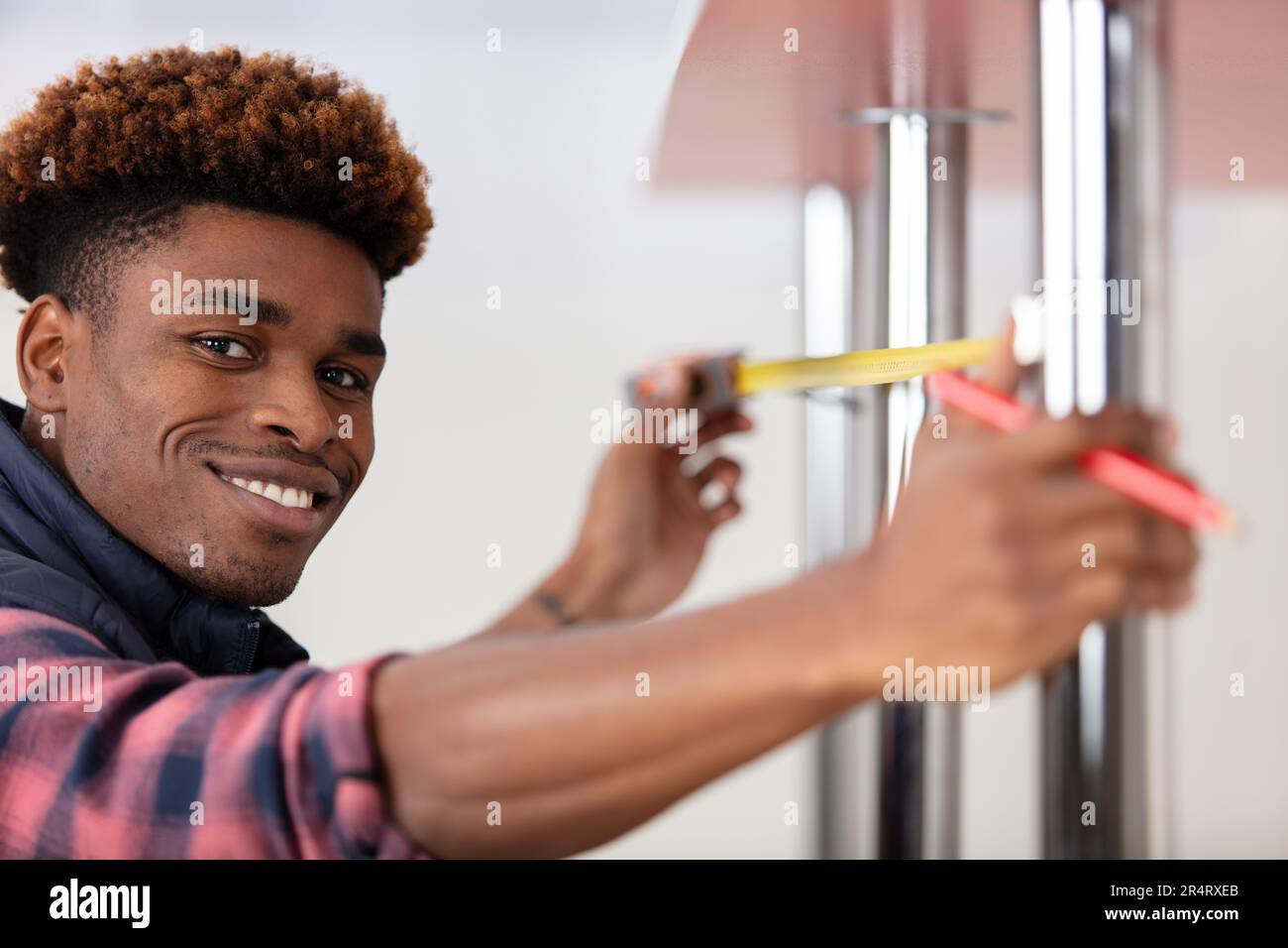 builder measuring a table using a tape measure Stock Photo - Alamy