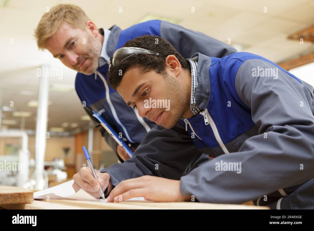 architect with architectural drawing and apprentice Stock Photo - Alamy