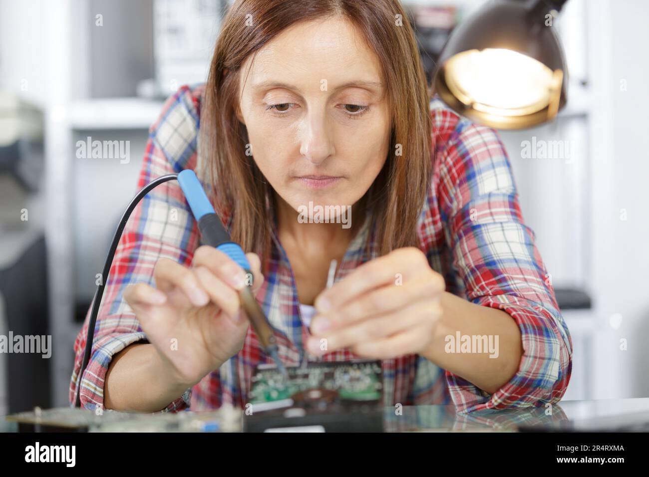 industrial worker woman soldering electric device Stock Photo - Alamy