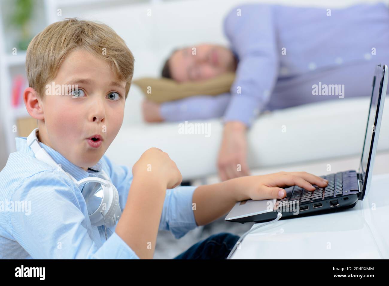 Young boy on laptop with shocked expression Stock Photo - Alamy