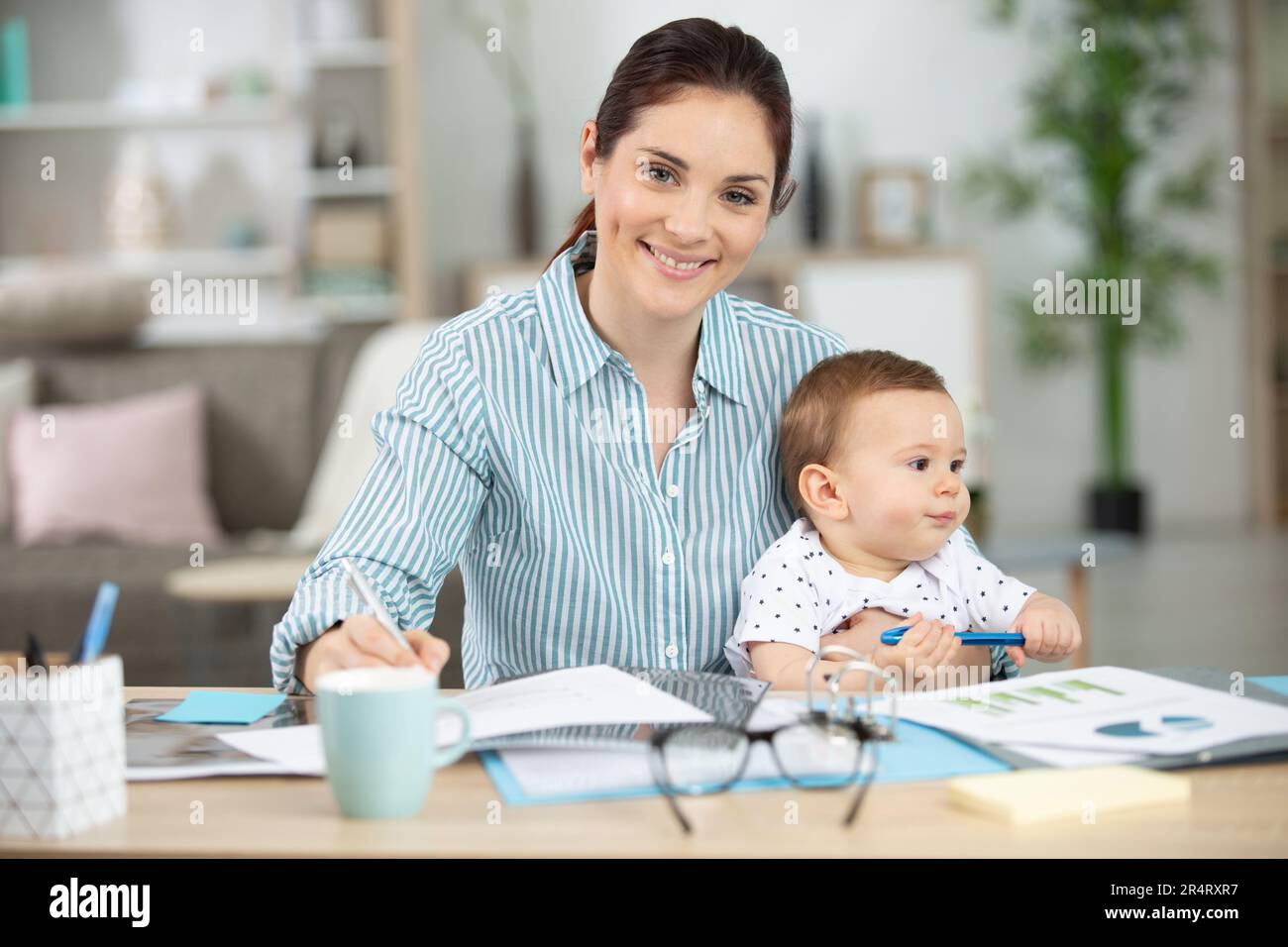 working mom with baby in a lap Stock Photo - Alamy