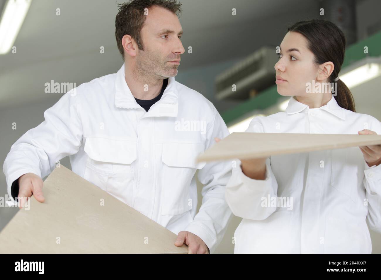 workman and woman checking wood boards Stock Photo - Alamy