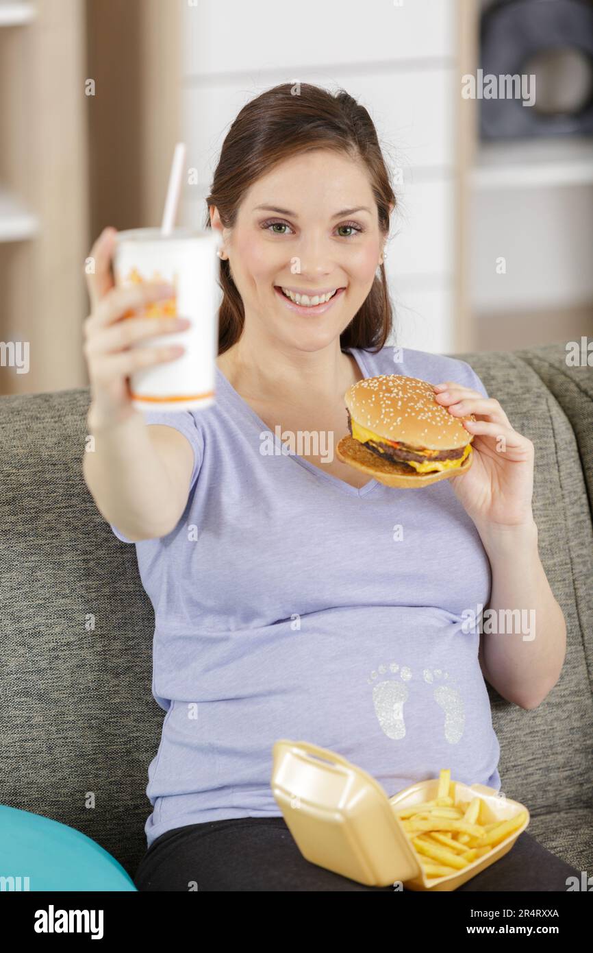 happy pregnant woman eating a burger Stock Photo - Alamy