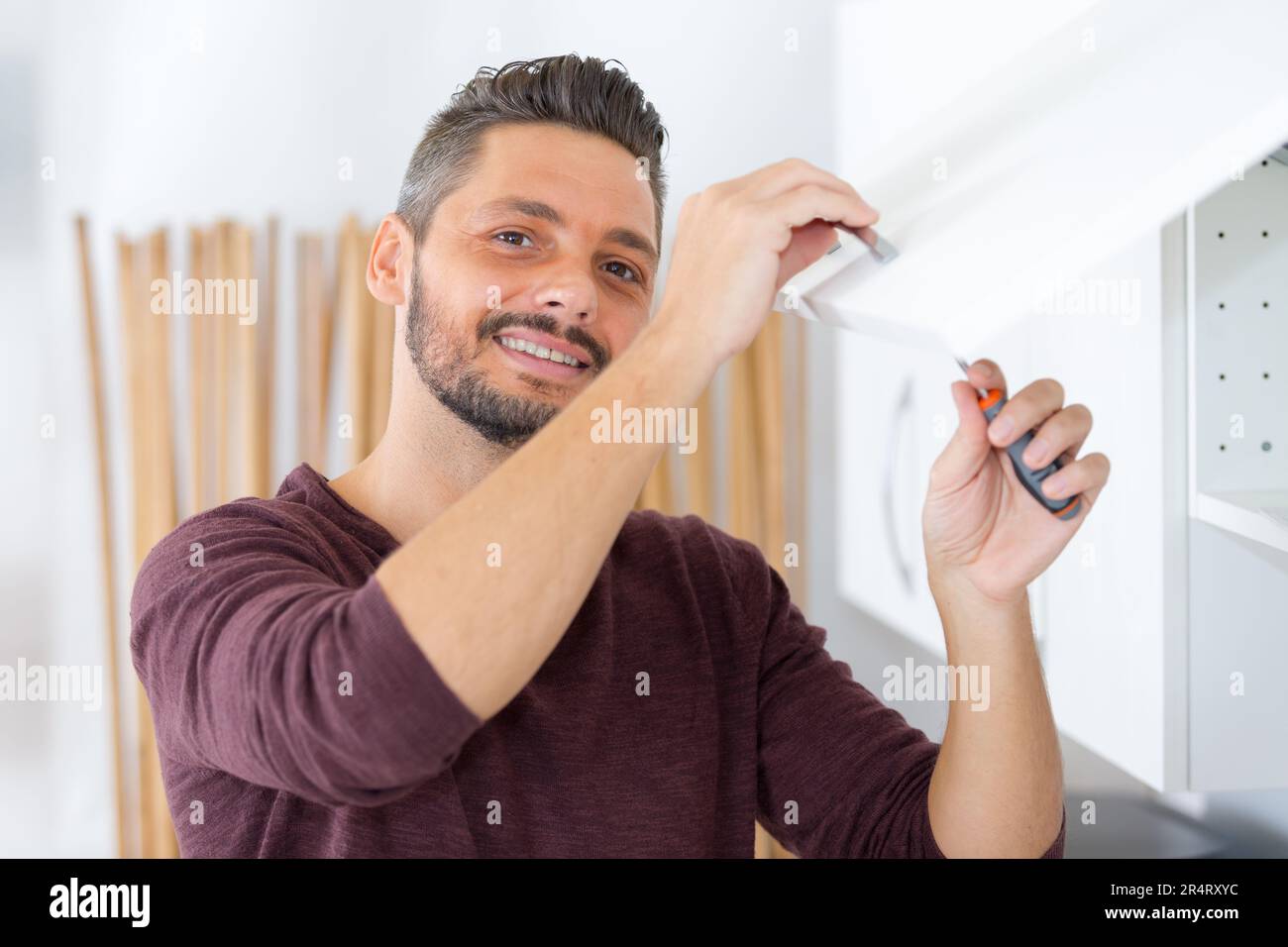 man installing kitchen cupboard Stock Photo - Alamy