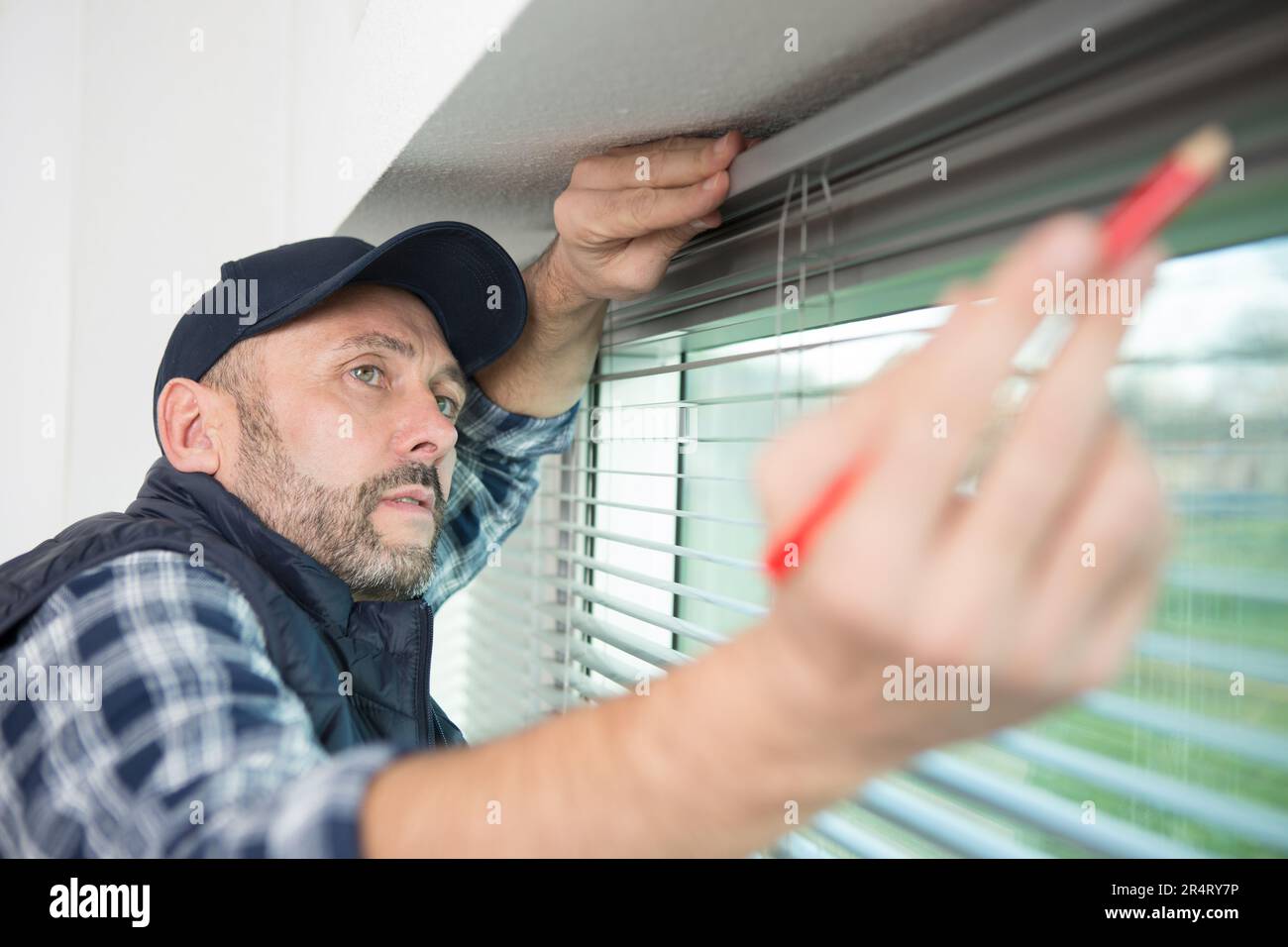man installing roller blinds on windows Stock Photo - Alamy