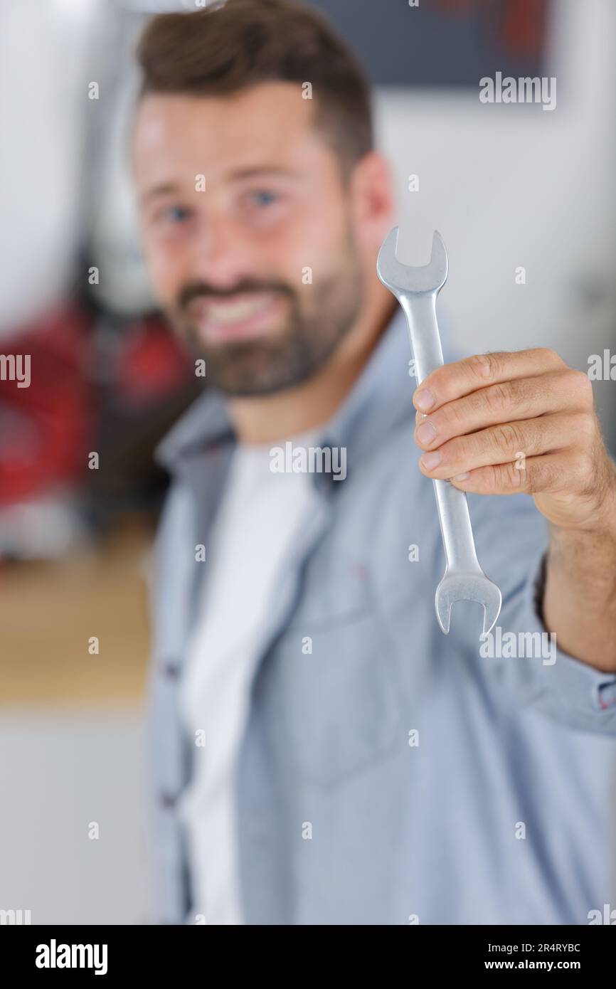 portrait of smiling male mechanic showing spanner Stock Photo - Alamy