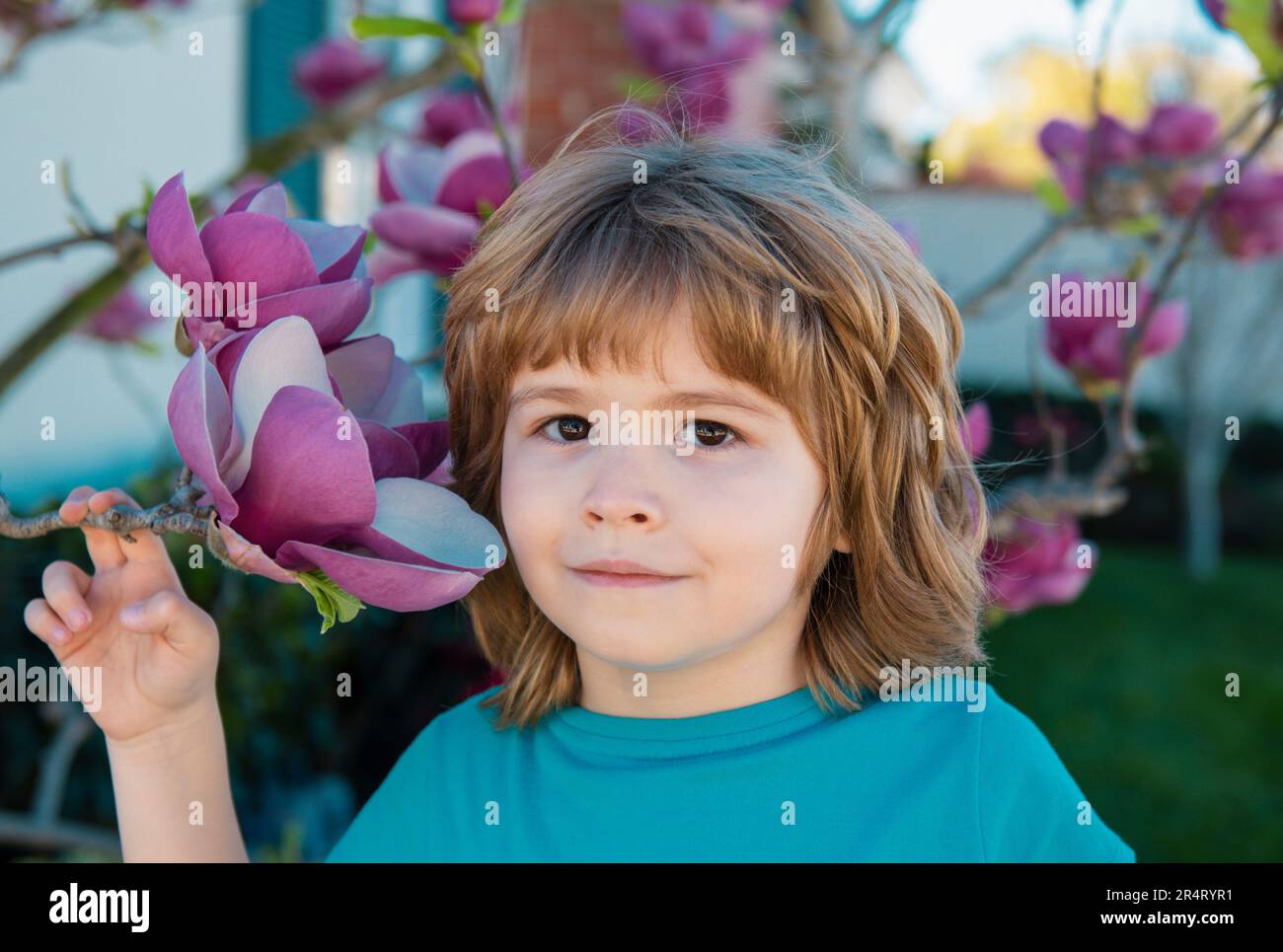 Spring kid with flower tree. Cute child in blossom garden. Happy boy at ...