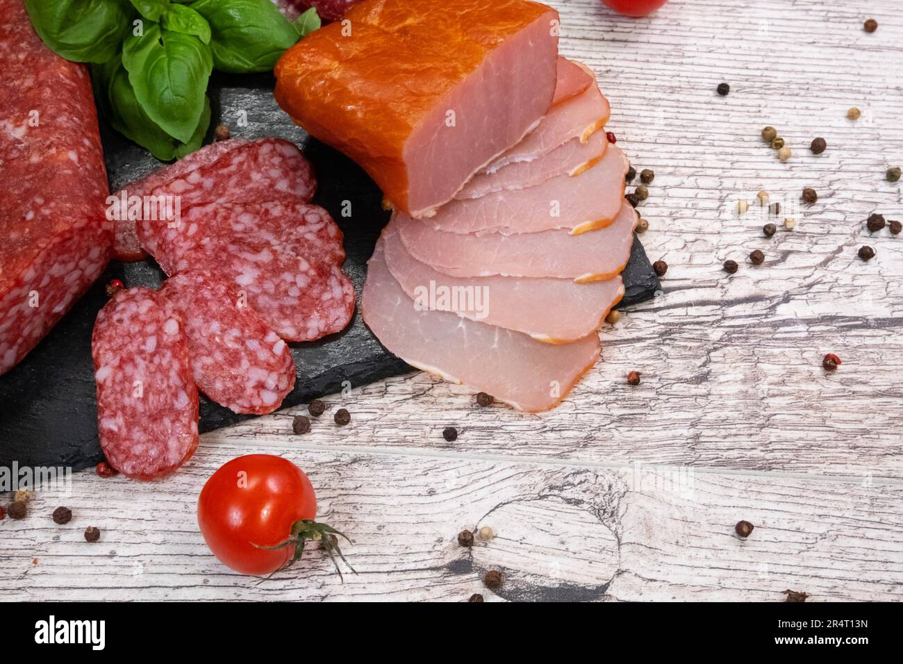 Antipasti different types of sausages and lard on a graphite board .Top ...