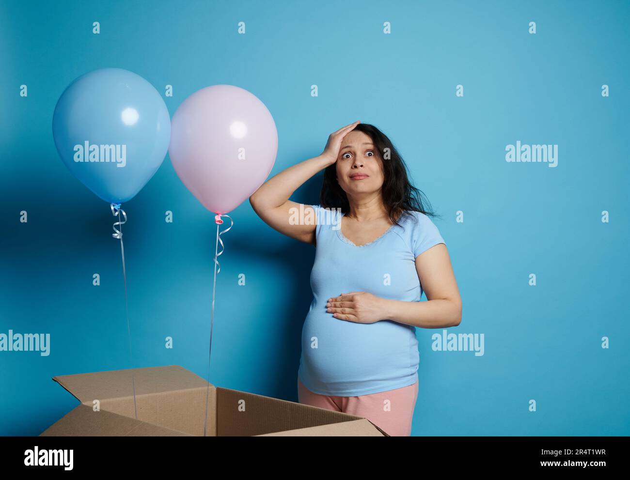Emotional portrait of pregnant woman touches her belly, expressing ...