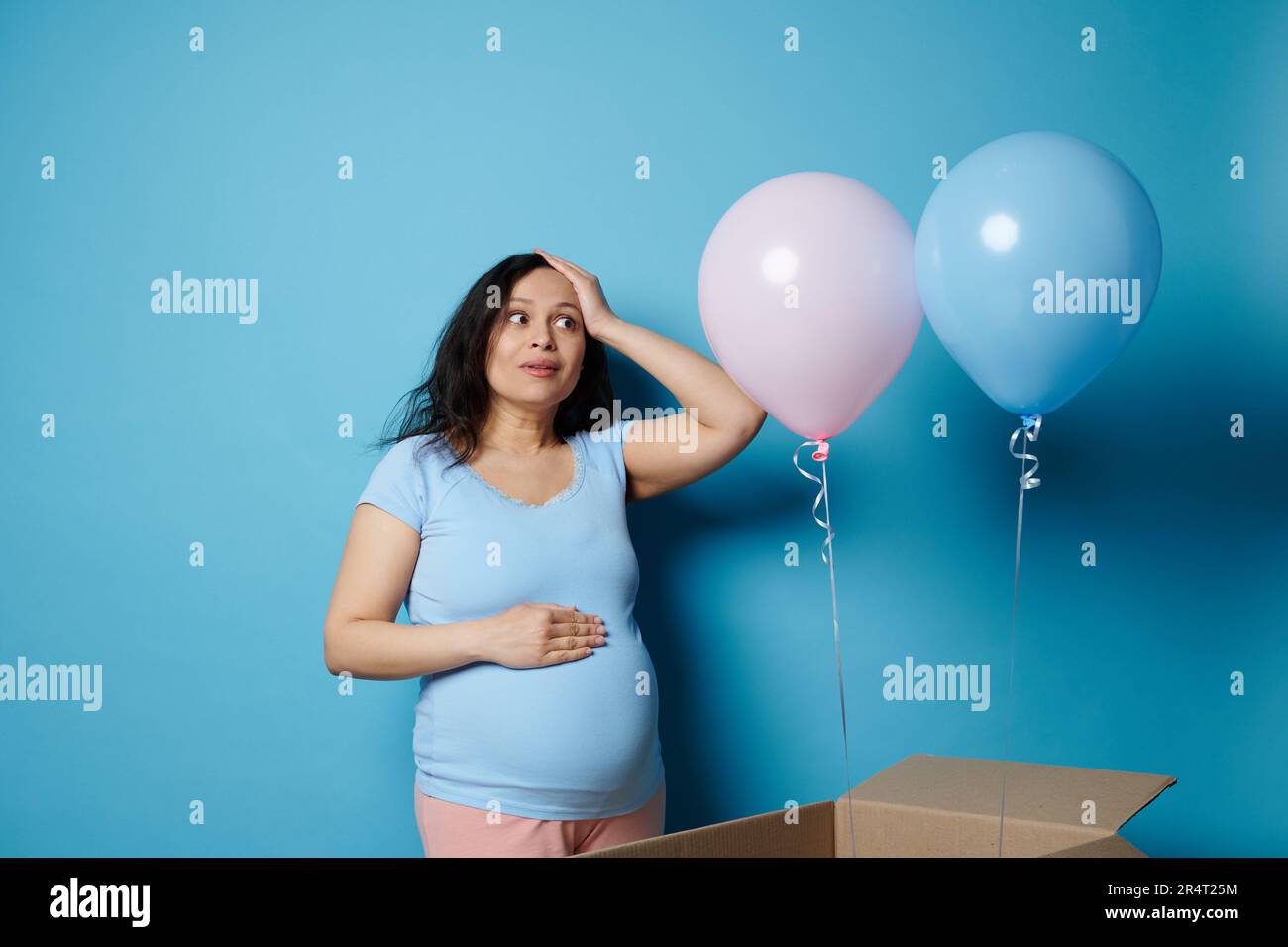 Pretty pregnant woman surprised by a gender reveal party, in ...