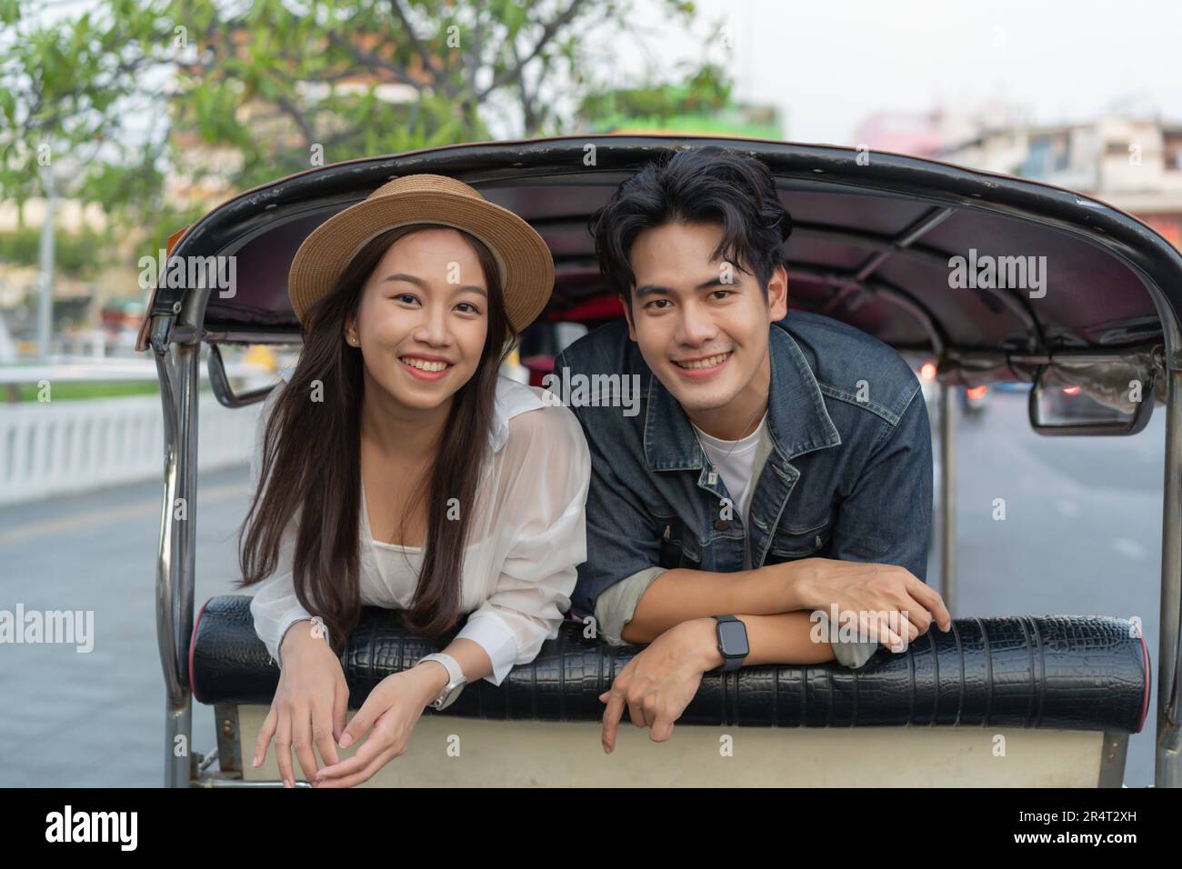 Happy and joyful Young Asian couple traveler tourists riding a tuk tuk ...
