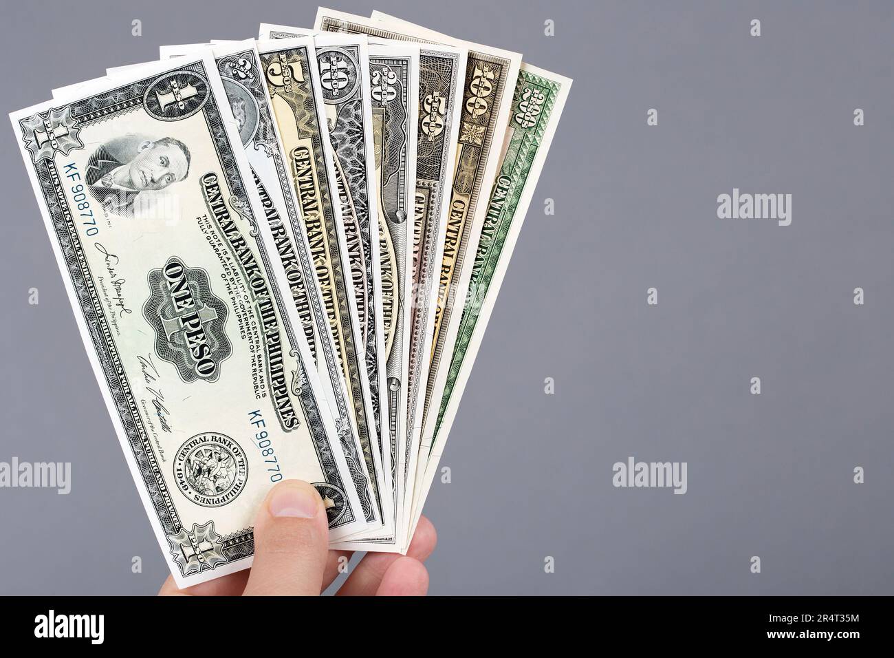 Old Philippine money - peso in the hand on a gray background Stock ...
