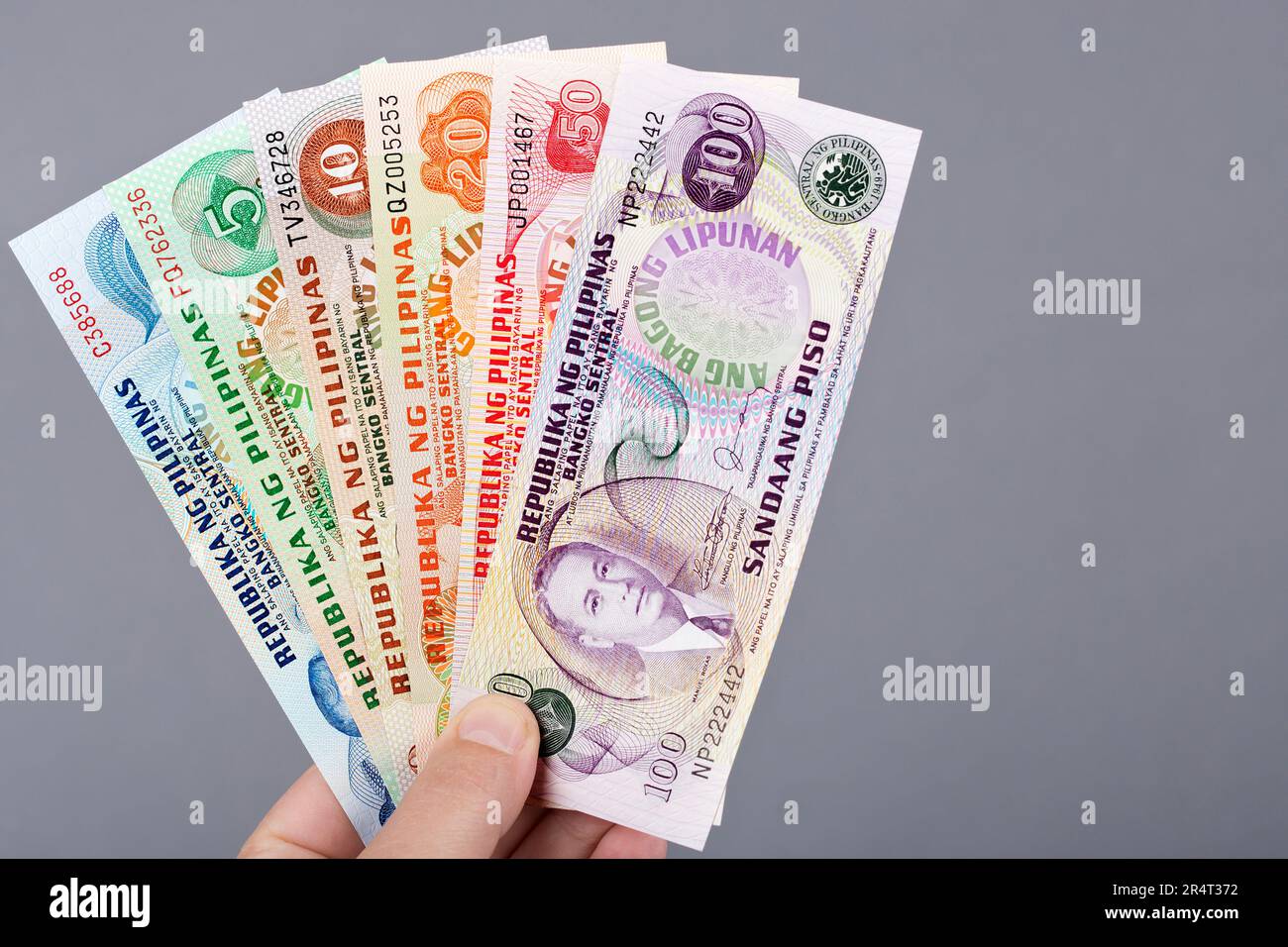 Old Philippine money - peso in the hand on a gray background Stock ...