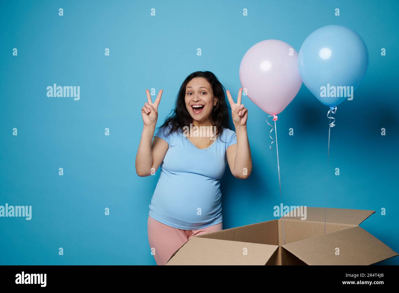 Lovely pregnant woman expresses happy positive emotions at gender party ...