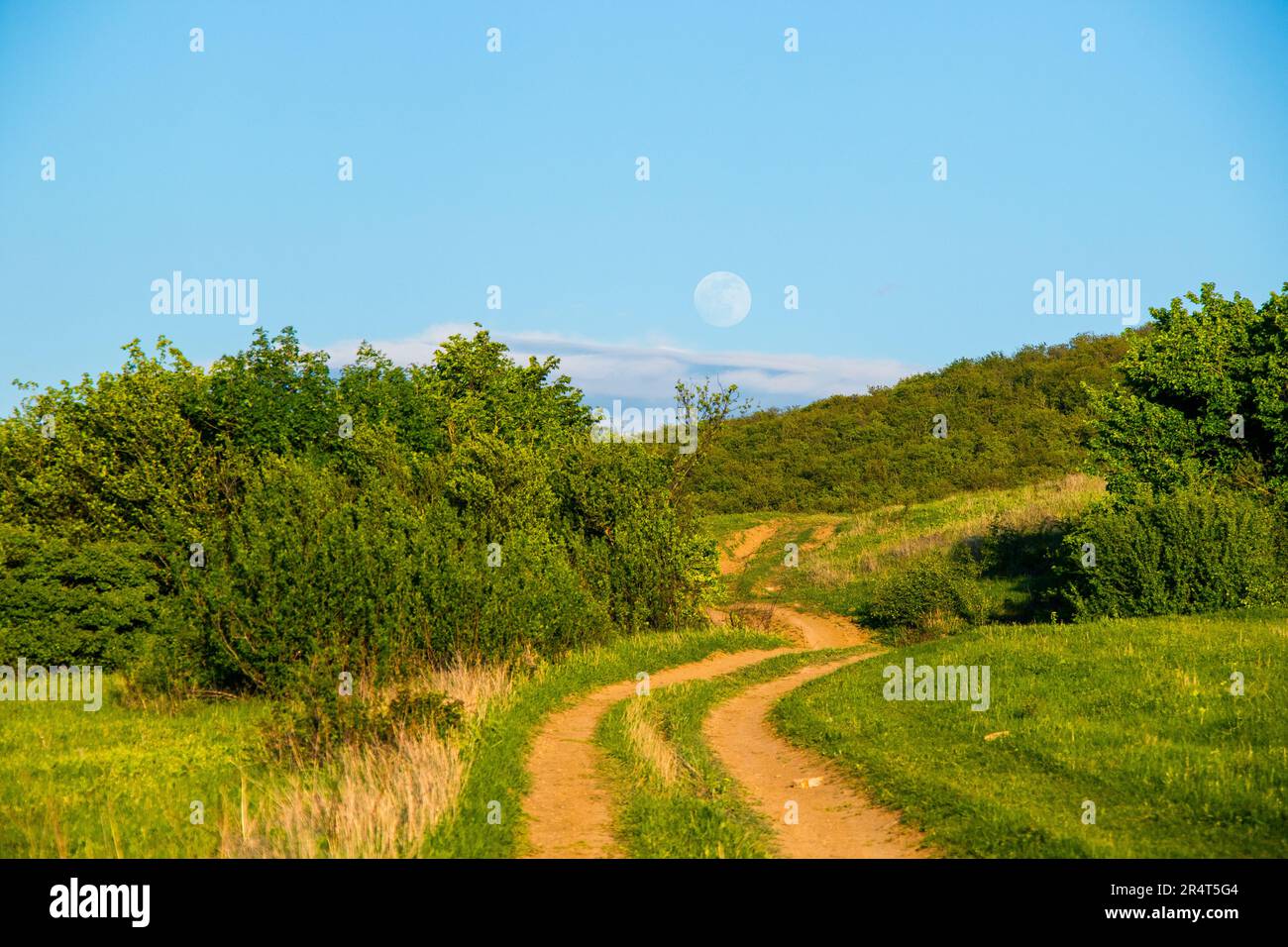 Moon in daylight, road landscape and moon Stock Photo - Alamy
