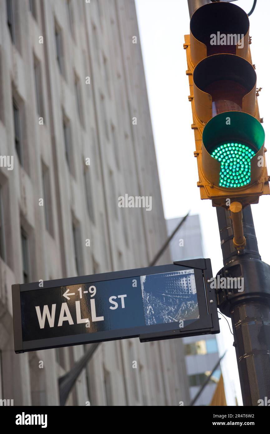 US, New York, Green traffic light and the street sign for wall street ...