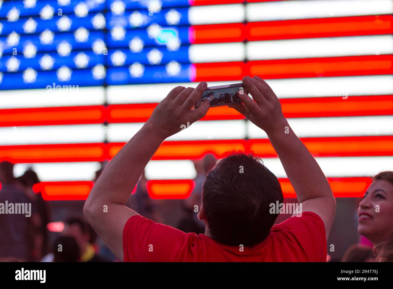 US, New York, neon US flag in times square with people taking pictures ...