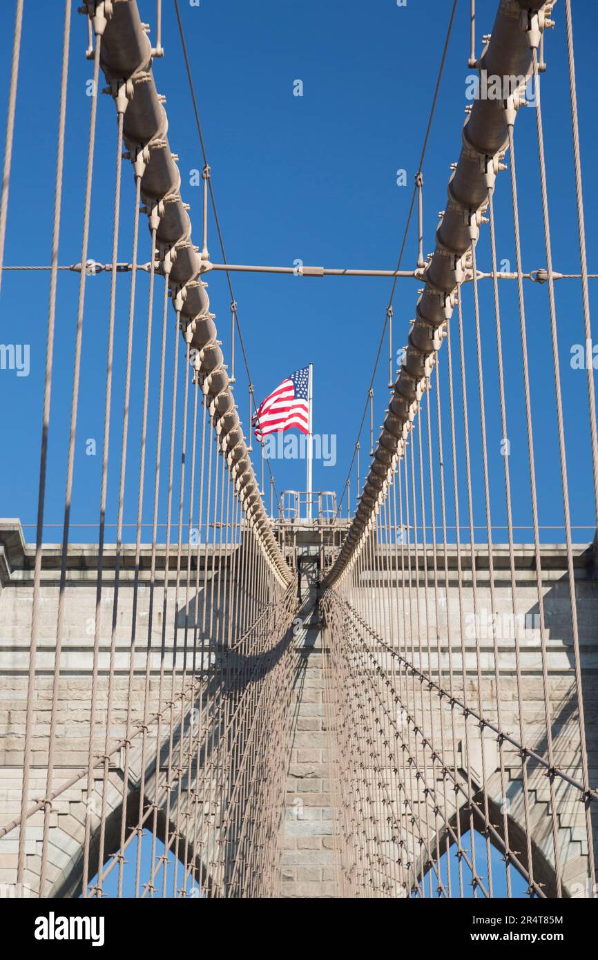 US, New York, Brooklyn Bridge walkway with Pylon and cables and US Flag ...