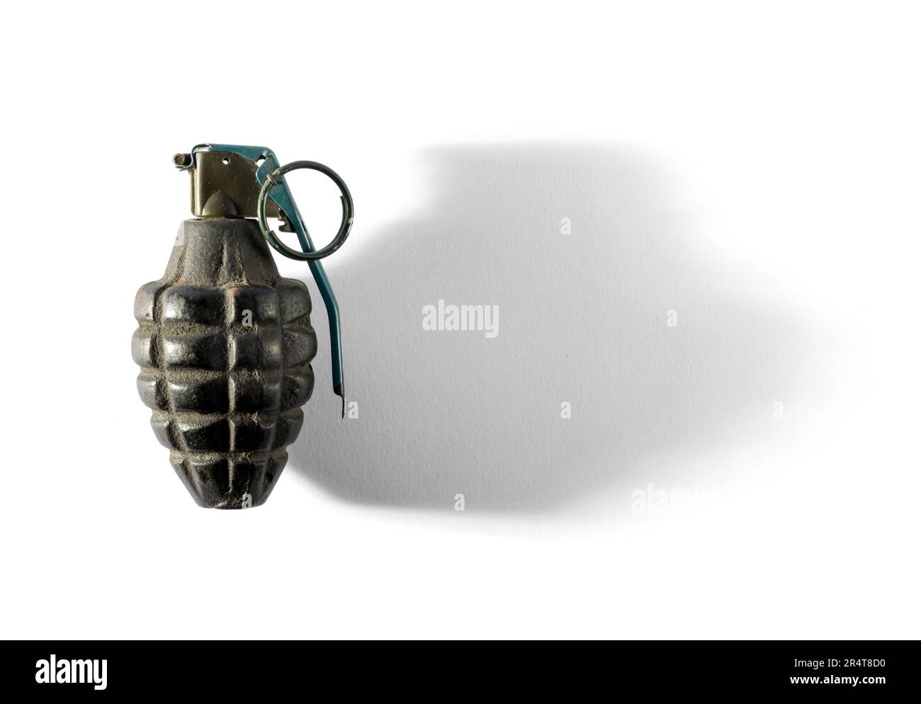Top view of metal hand grenade with safety clip placed on white ...