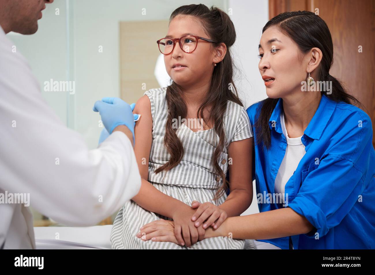 Girl almost crying when doctor injecting vaccine in her forearm Stock ...